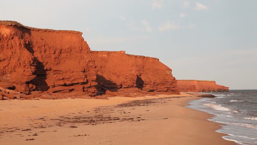 Waves Rolling In On An Empty Beach With Red Sandstone Cliffs On Prince ...