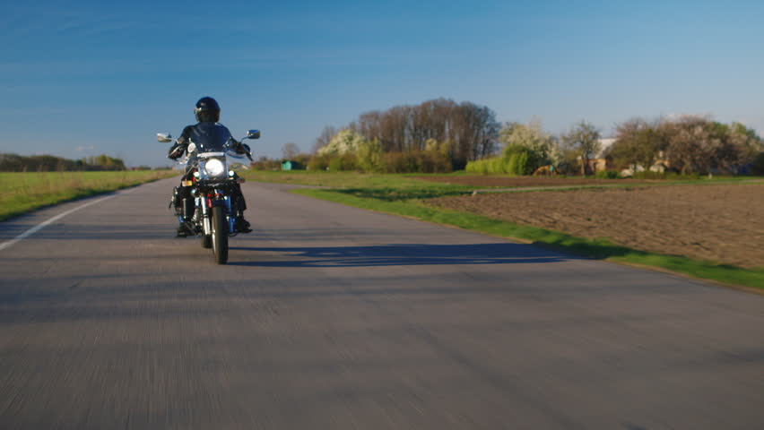 A Biker Riding A Customized Motorcycle On An Open Road Stock Footage ...