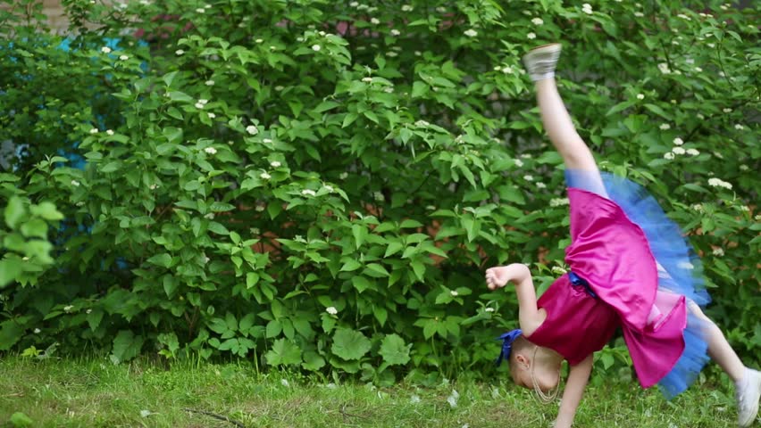 Little Girl In Pink Dress And Swimsuit Cartwheels Across Beach Stock ...