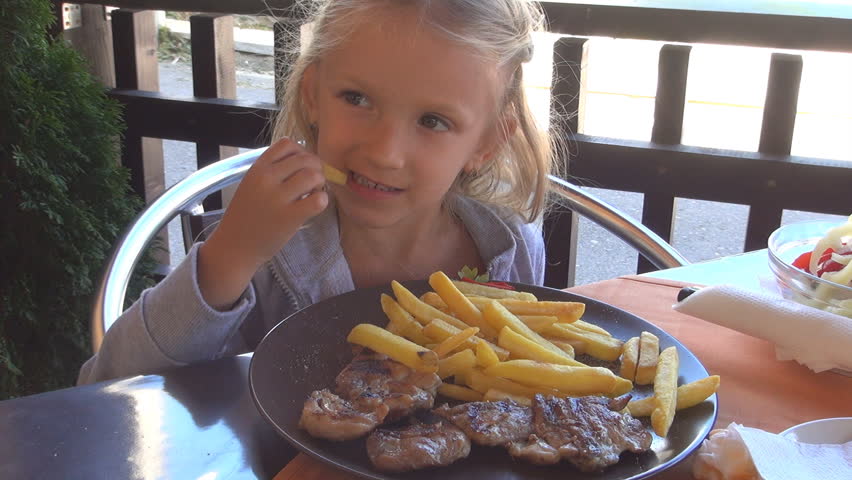 Child Eating Fries, Potatoes, Child Licking Fingers At Restaurant, Bar ...